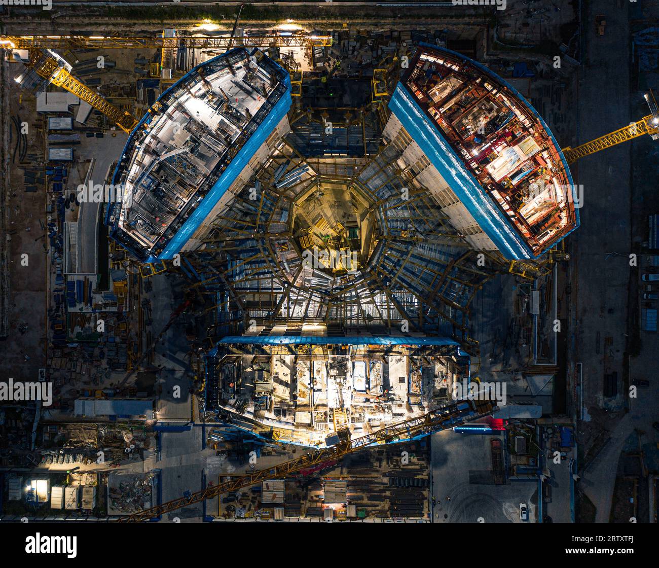 An aerial top view of modern skyscrapers under construction at night ...