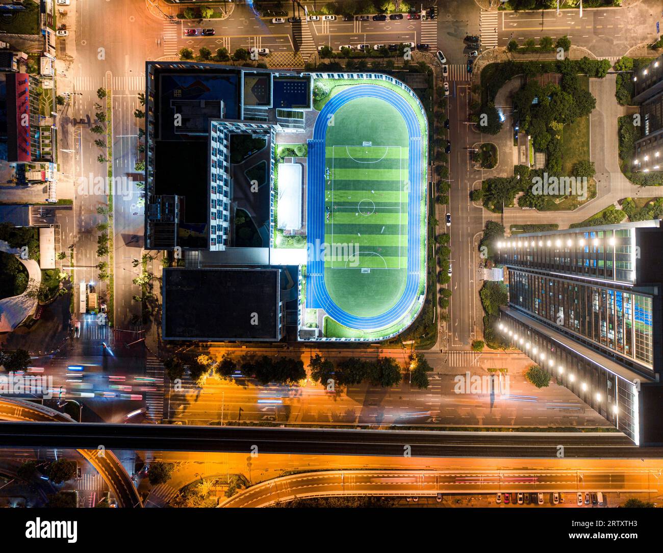 An aerial view of an illuminated soccer field on a tall building roof ...