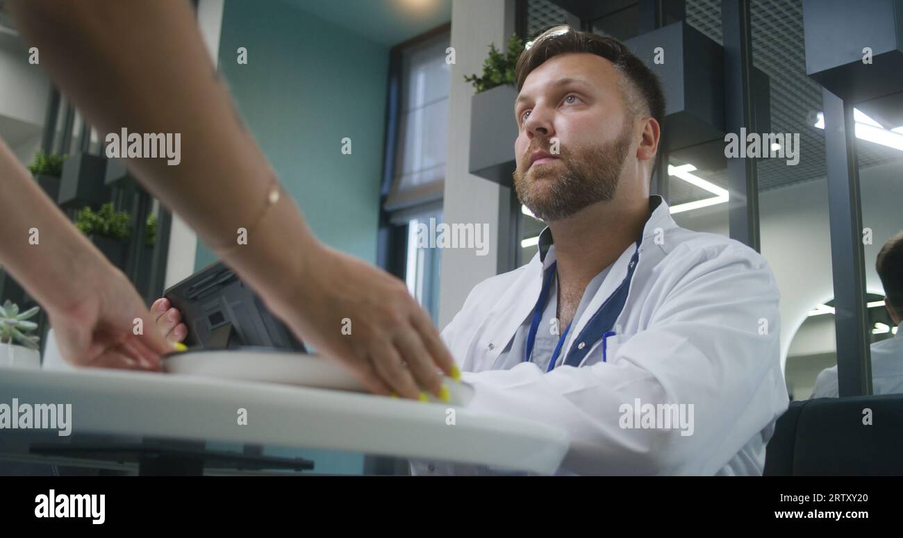 Healthcare specialist sits in medical center cafeteria. Male doctor ...