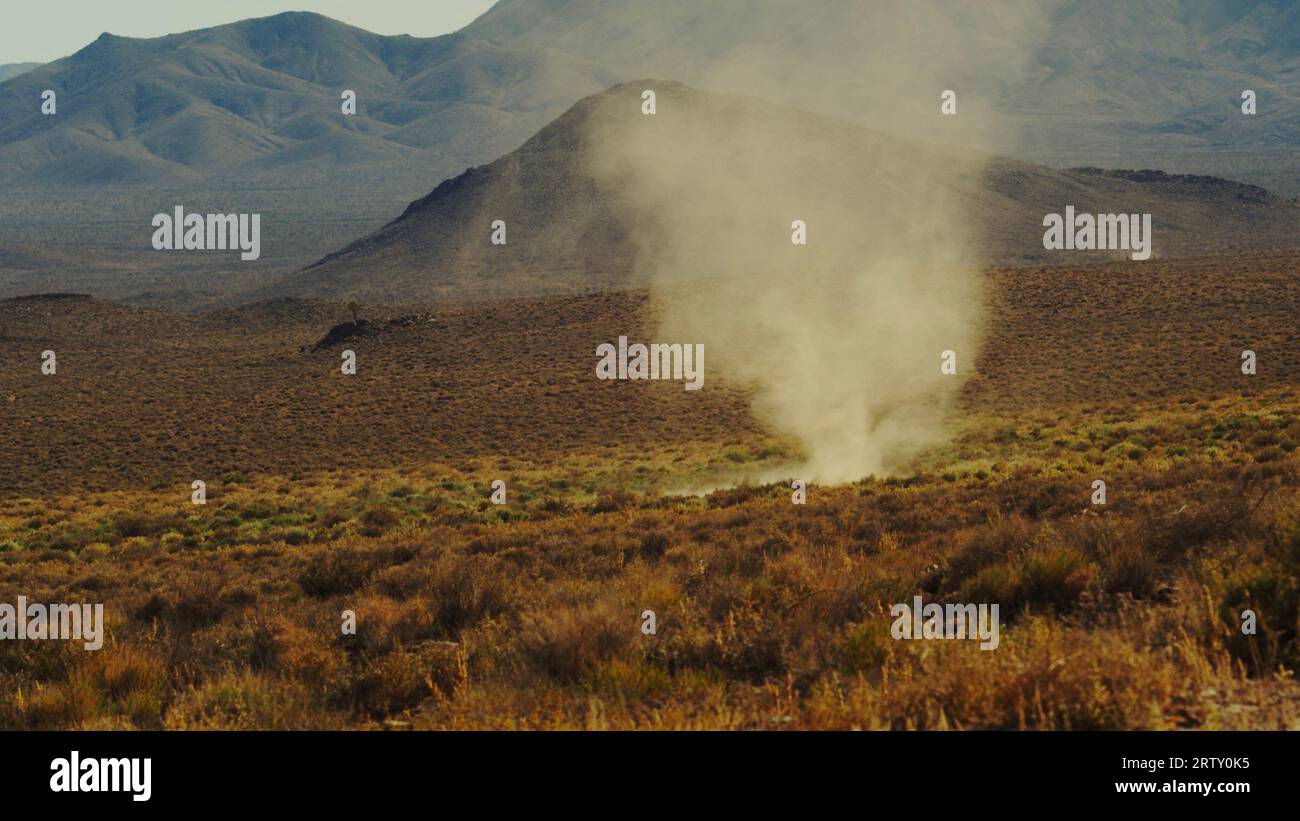 A furious dust devil churns, chews, rips and tears across a vast playa ...