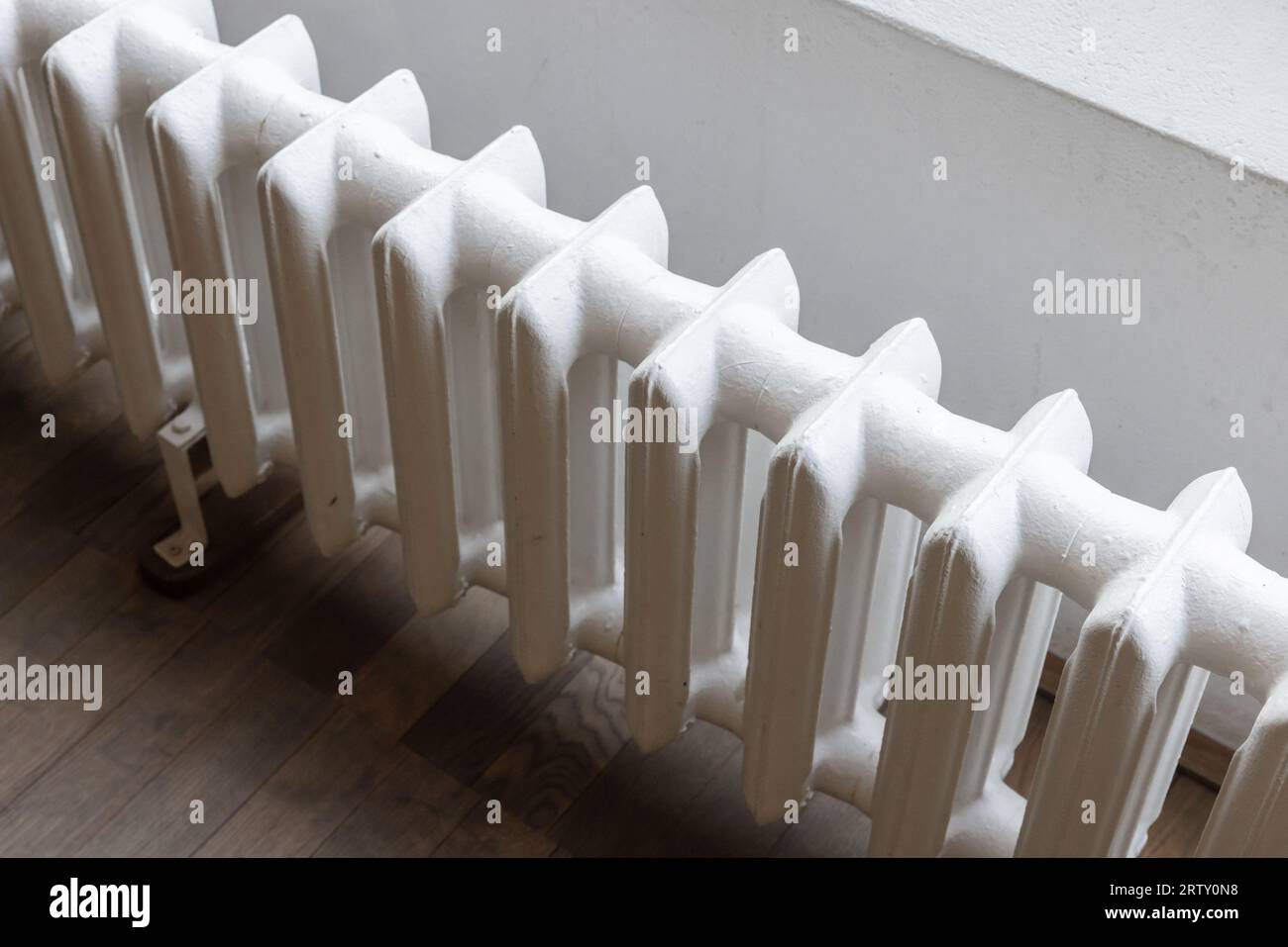 White radiator in front of the windowsill. Classic urban house heating ...