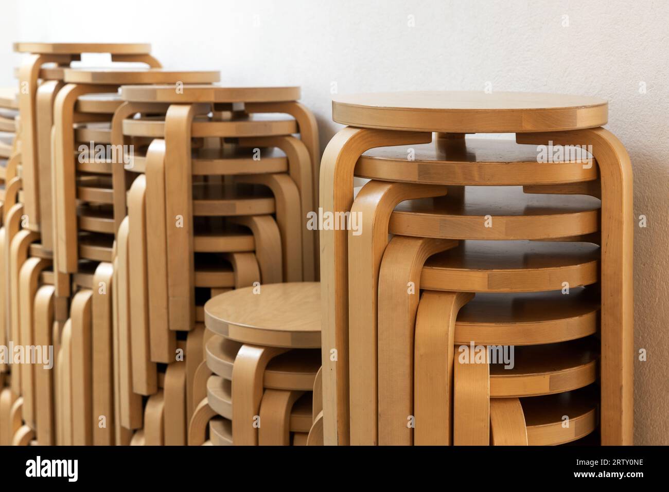 Stacked round wooden stools made from bent plywood Stock Photo - Alamy