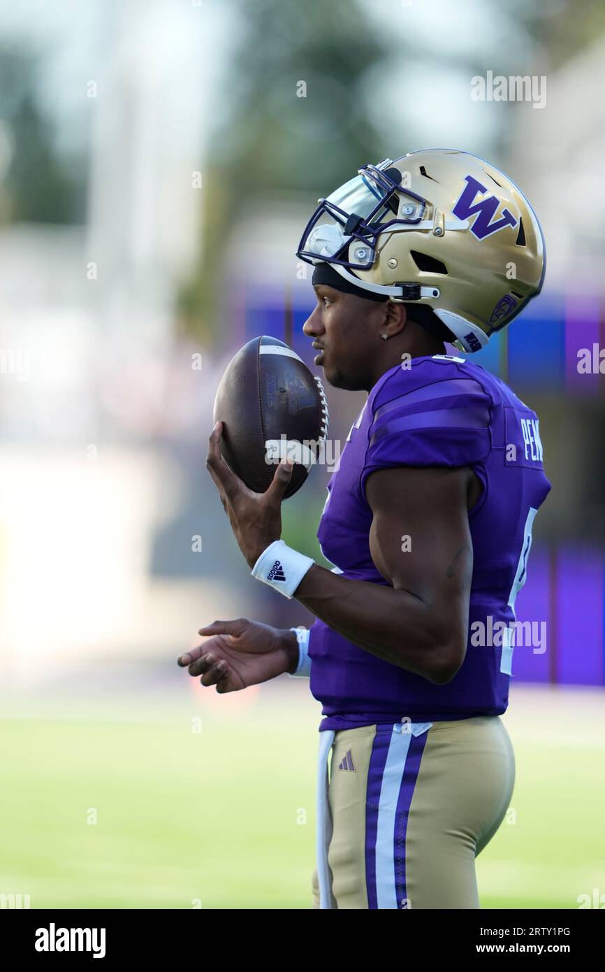 Washington quarterback Michael Penix Jr. holds a football during warmups before an NCAA college ...