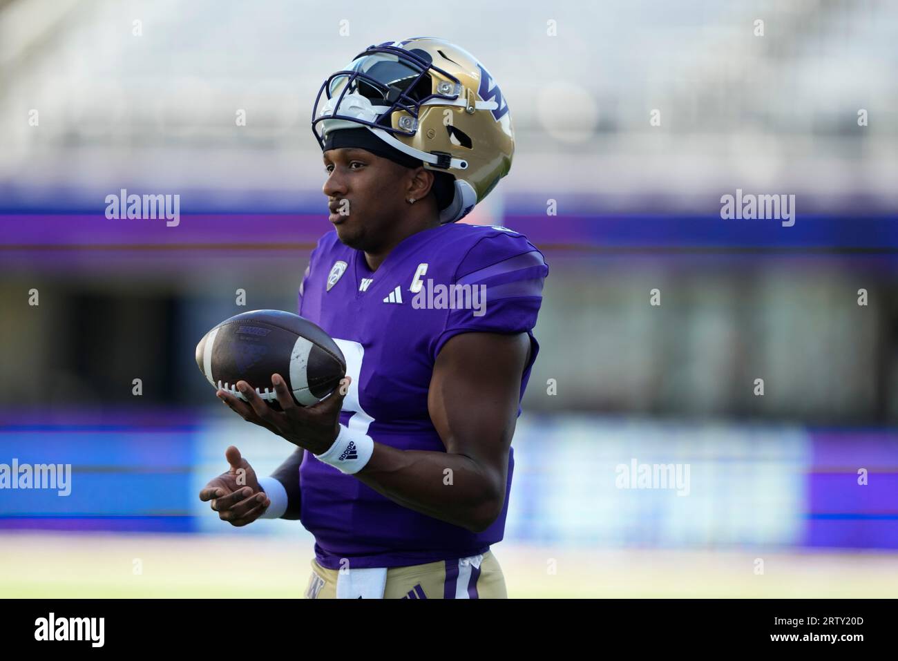 Washington quarterback Michael Penix Jr. holds a football during warmups before an NCAA college ...
