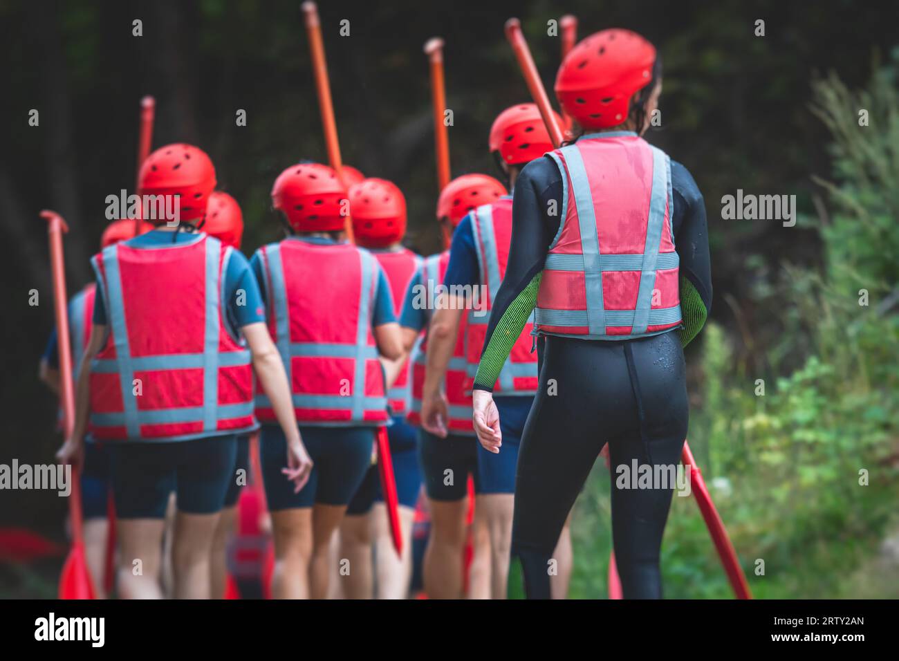 Group of sportsmen in wetsuits with paddles in helmets and life jackets ...