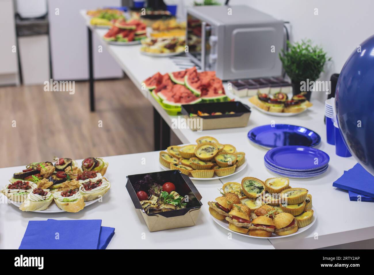 Office party catering, table with variety of different food snacks on ...
