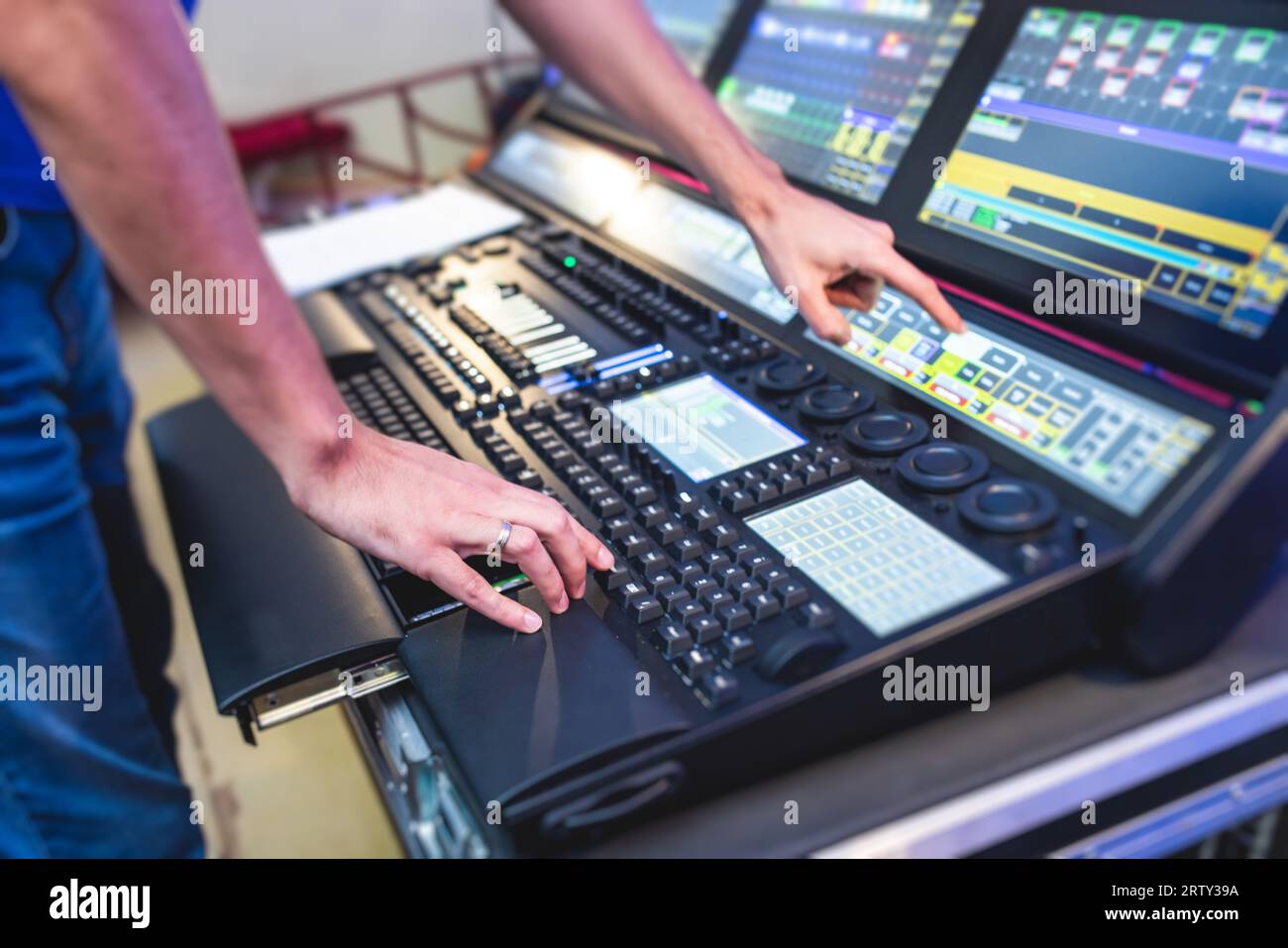 View of a lighting technician operator working on mixing console ...