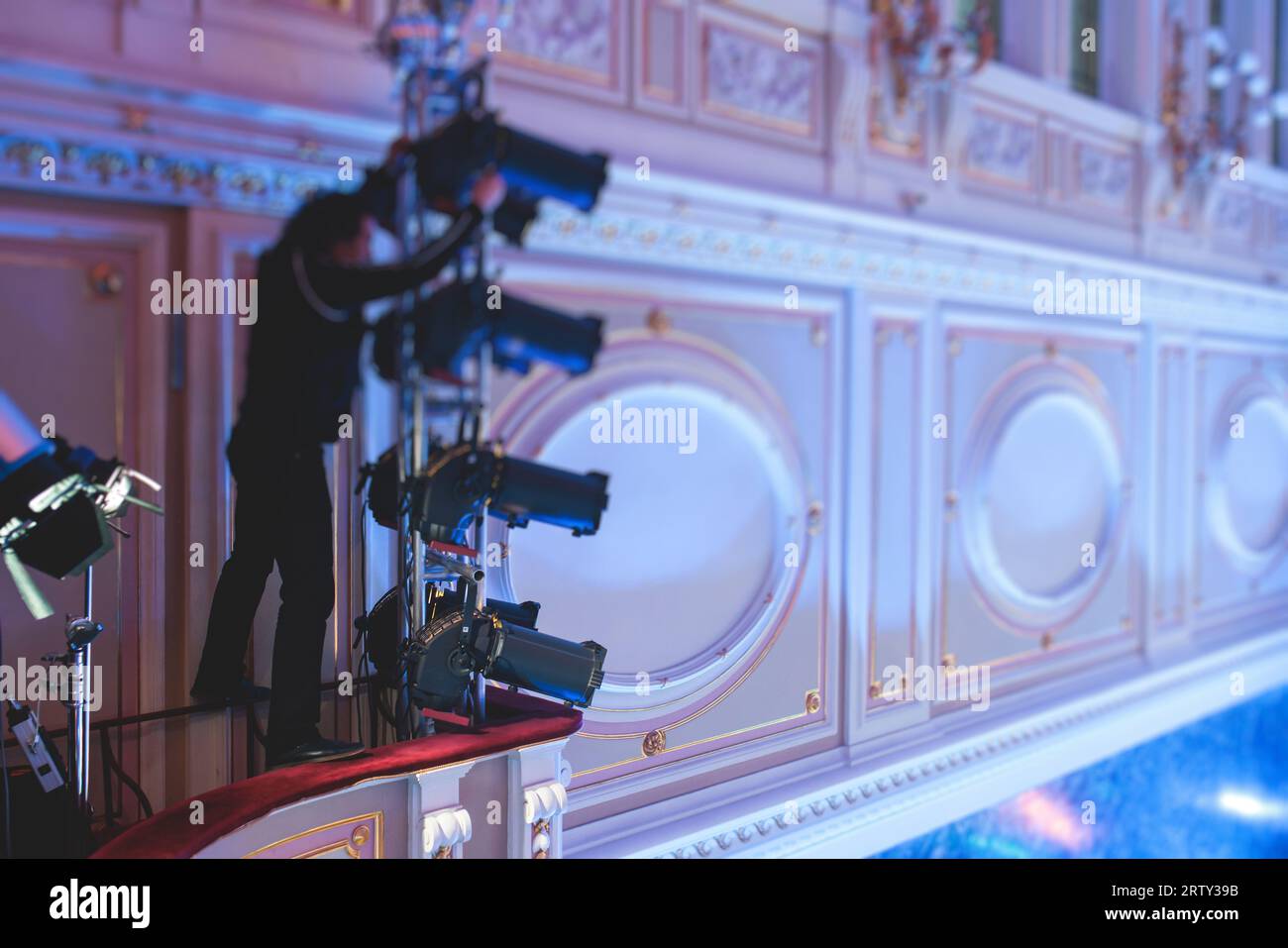 Stage worker assistant sets up lights, light engineer, lighting ...