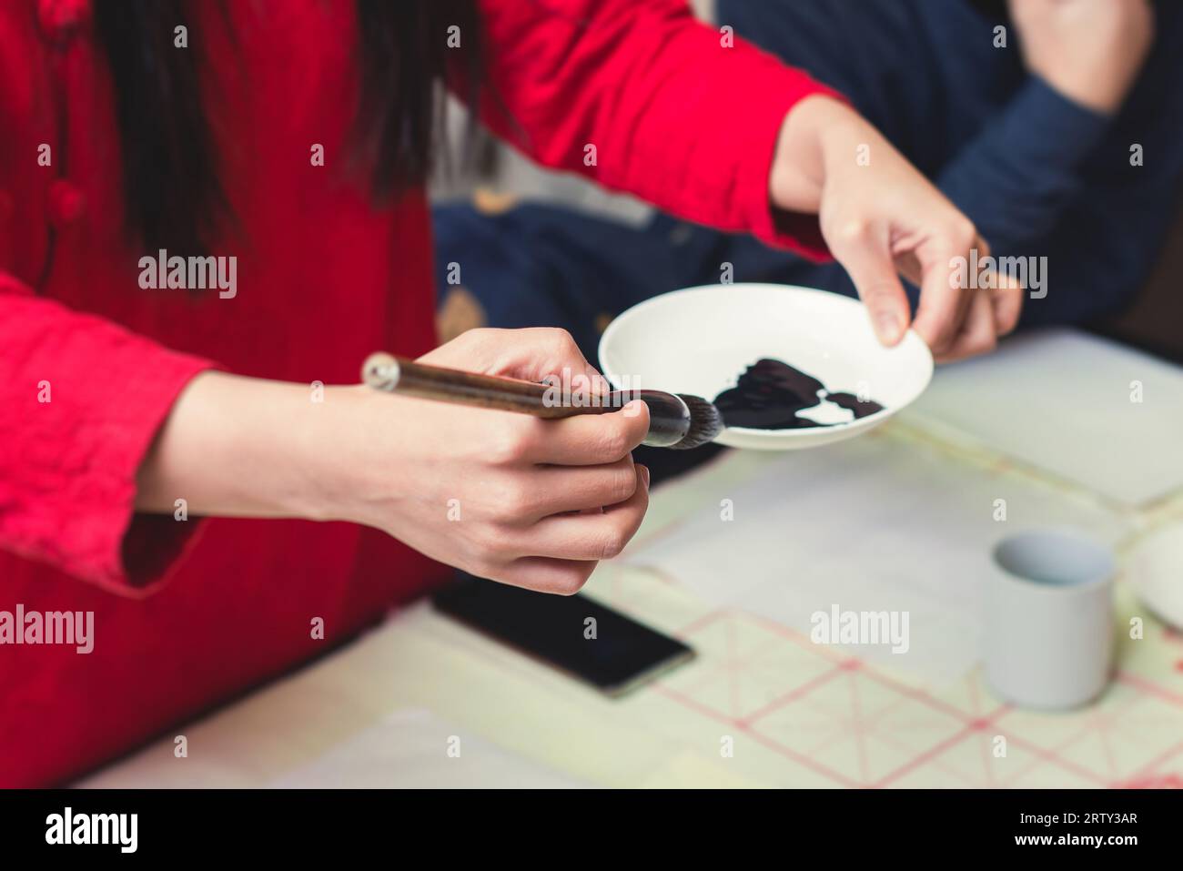 Chinese calligraphy lesson, group of kids learn and practicing traditional calligraphy in class ...