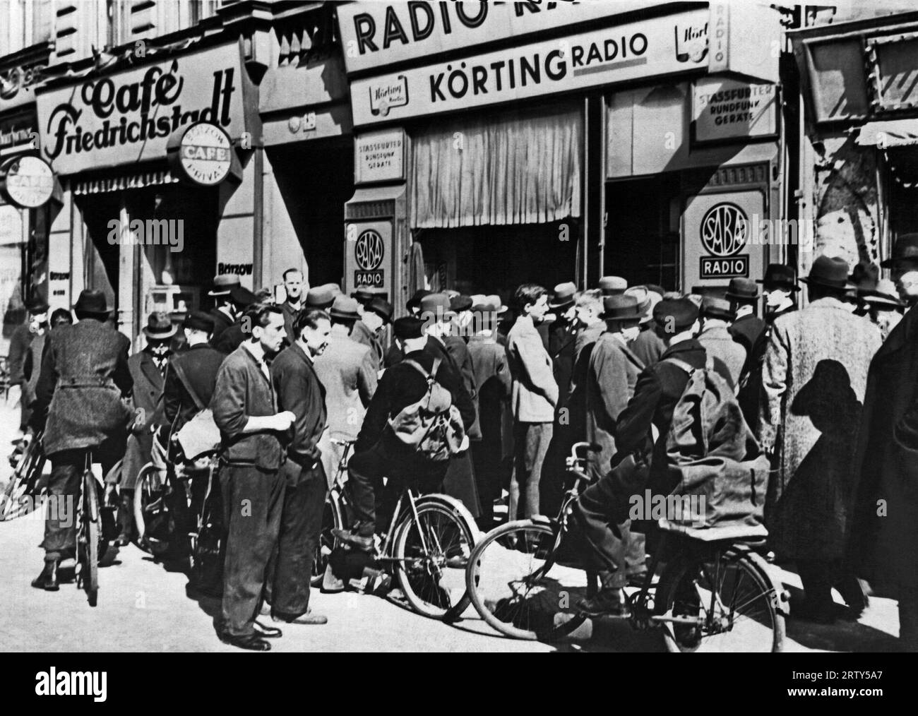 Berlin, Germany c. 1933 Pedestrians on the street stopping to listen to ...
