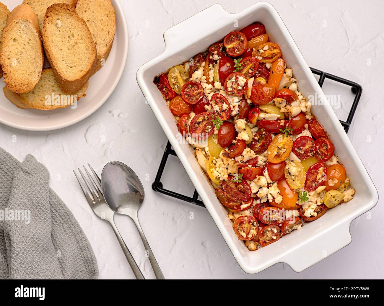 Food photography of salad, baked tomato; feta, cheese; garlic; thyme ...