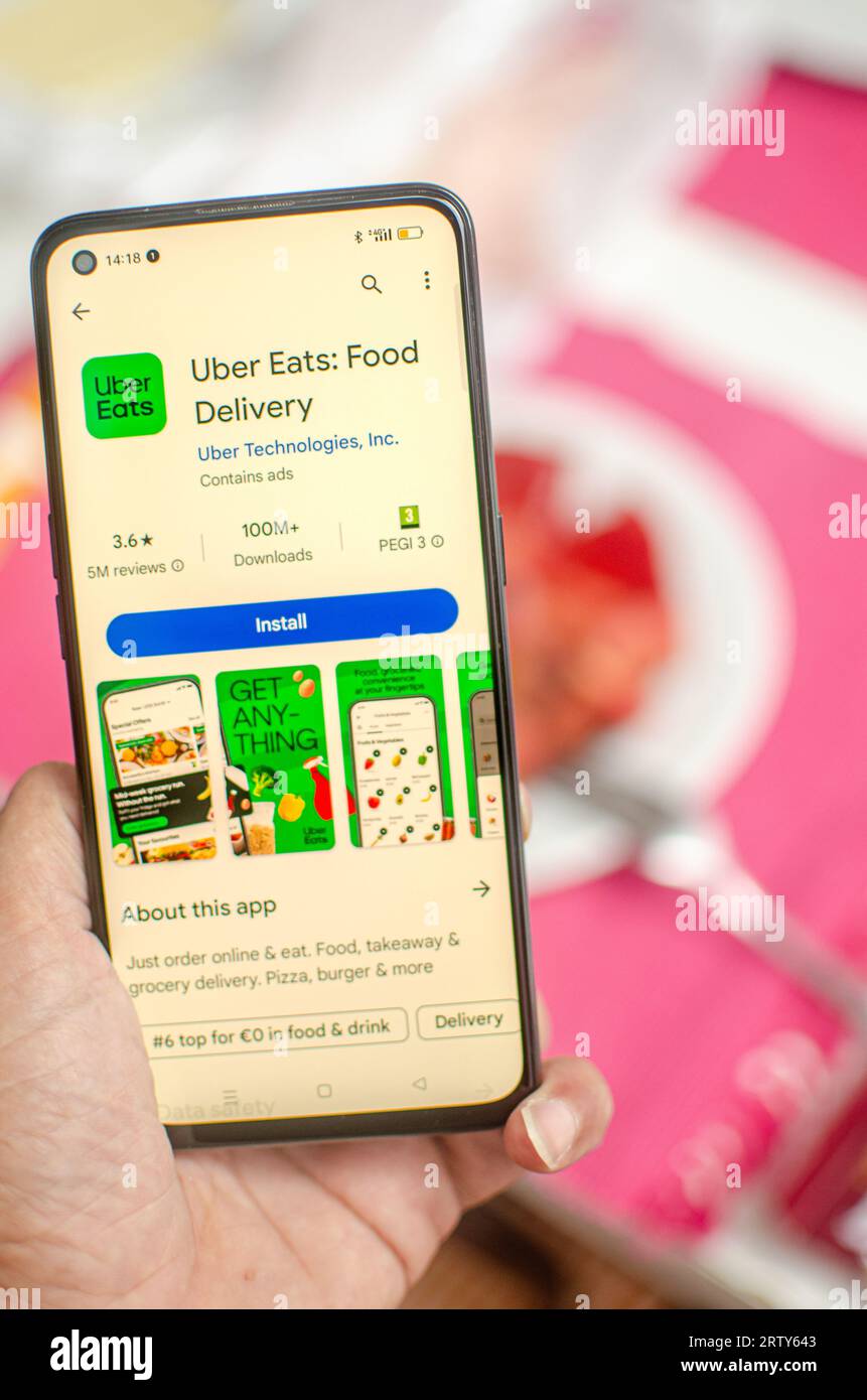 Madrid, Spain 09 12 2023: Hand holding a smartphone with the Uber Eats app for delivery food ...