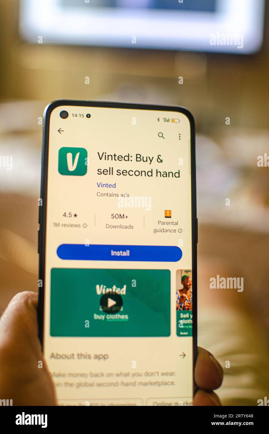 Madrid, Spain 09 12 2023: Hand holding a smartphone with the Vinted app ...