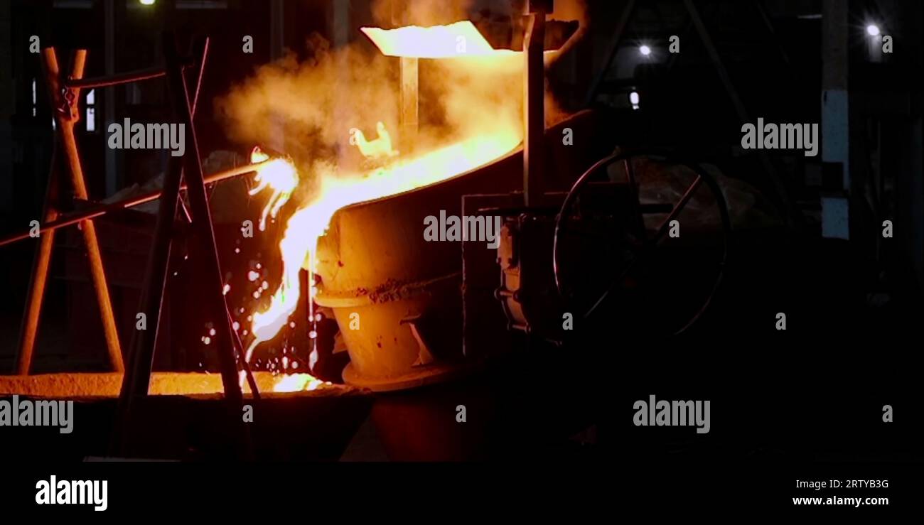 Hot molten metal being poured into a mold in a metallurgical plant ...