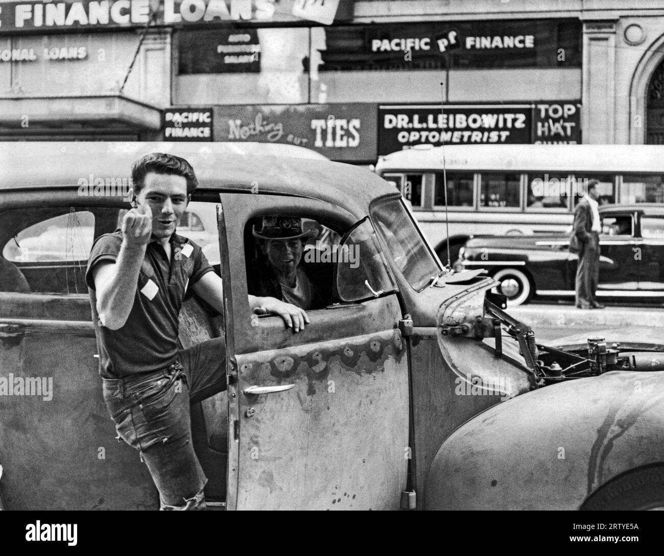 San Francisco, California: c. 1955 A teenager climbing into his friend ...