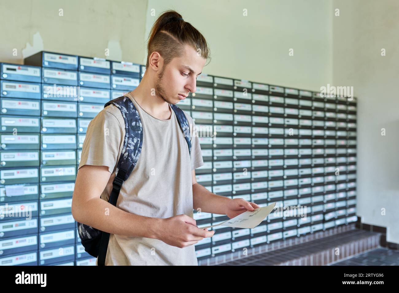 Young guy student reading an important mail letter near mailboxes Stock ...