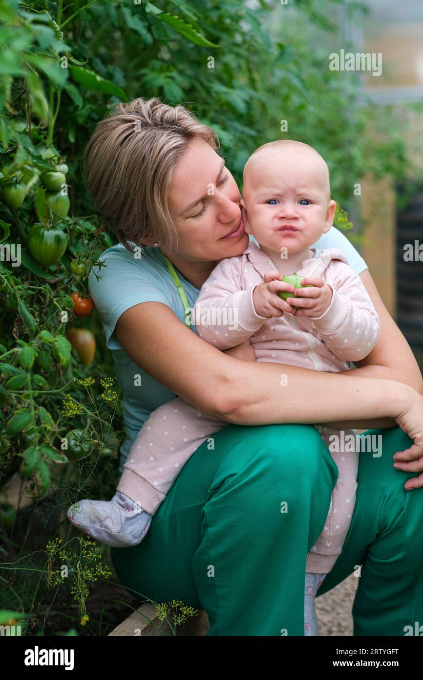 Woman and child growing bio plants in farm garden Stock Photo - Alamy