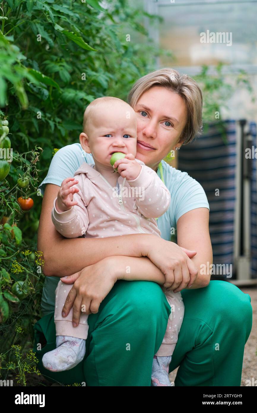 Woman and child growing bio plants in farm garden Stock Photo - Alamy