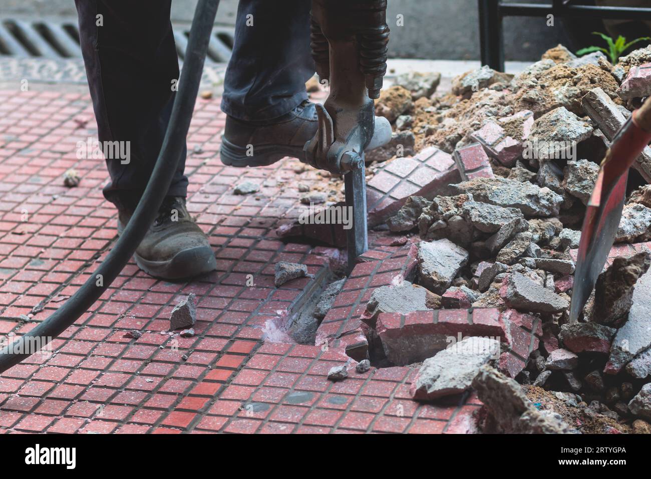 Process of sidewalk road repairing with jackhammer, builder worker with ...