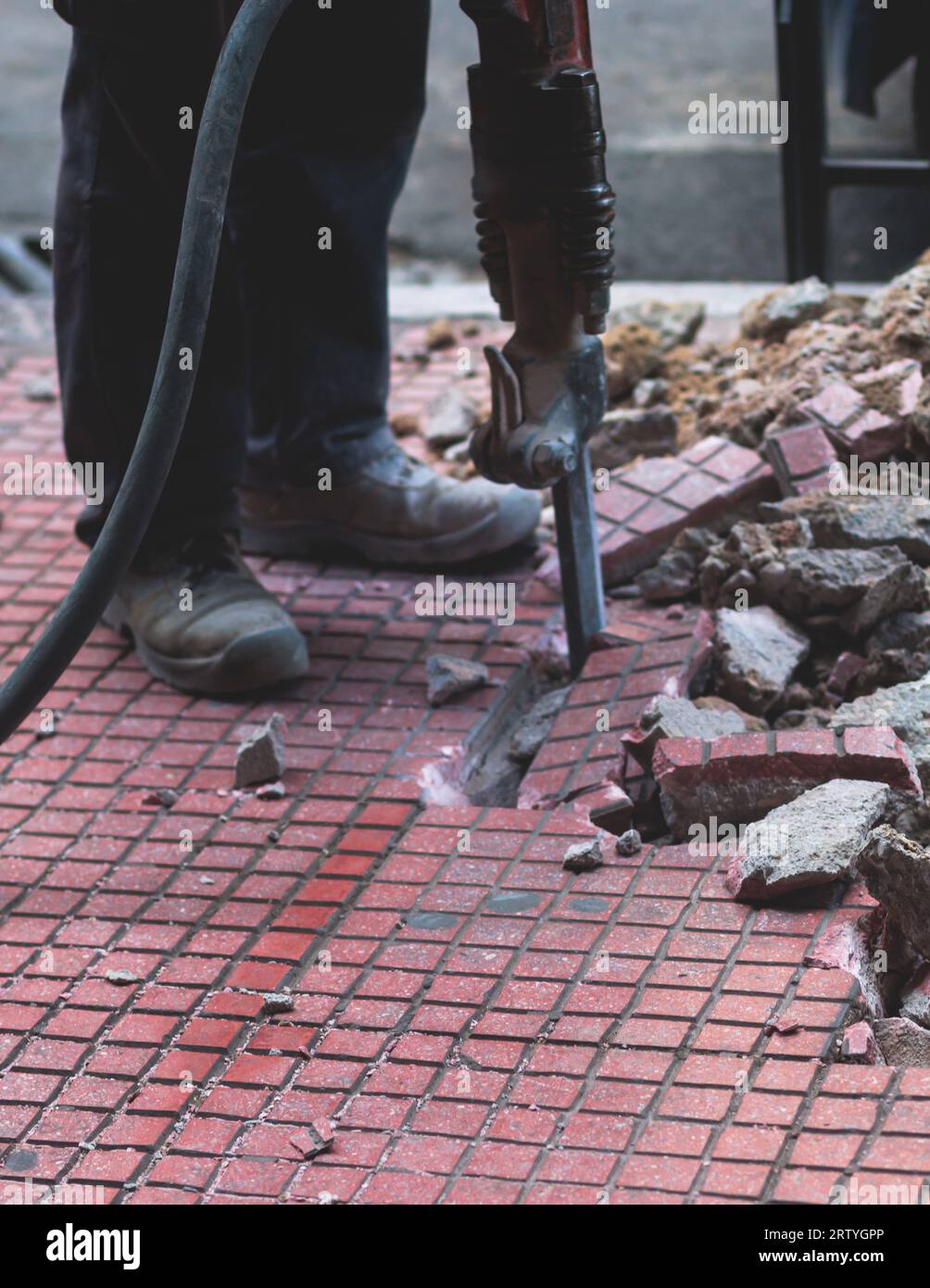 Process of sidewalk road repairing with jackhammer, builder worker with ...