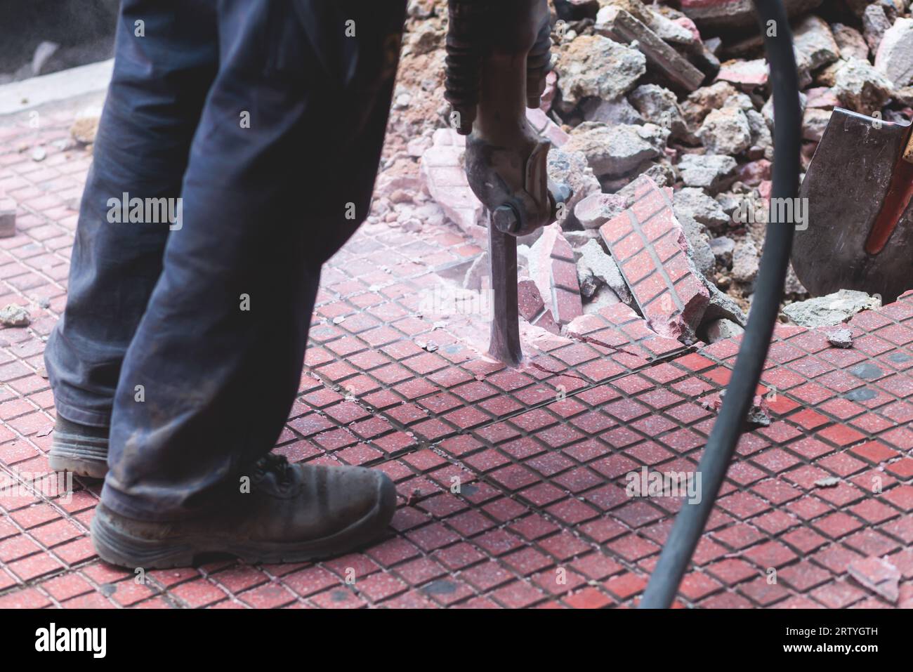Process of sidewalk road repairing with jackhammer, builder worker with ...