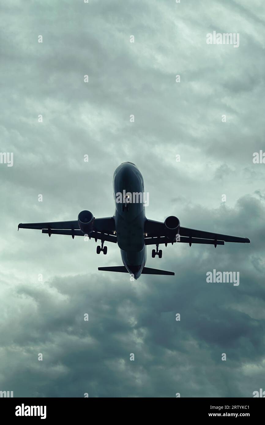 Closeup view of big airplane landing in the dark massive clouds. Planes ...