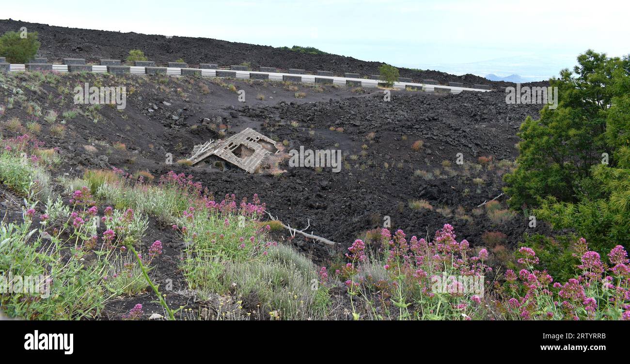 House covered with lava at the foot of Mount Etna volcano, surrounding ...