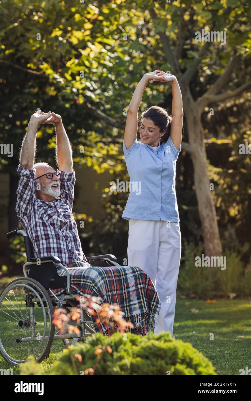 Senior man with disability in wheelchair stretching arms and doing ...