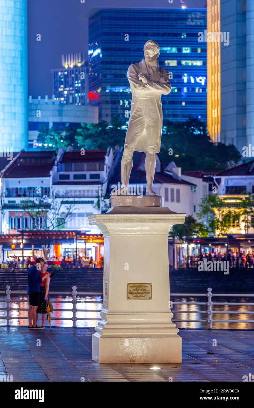 A night view of the statue of Sir Stamford Raffles on the North Bank of the Singapore River ...