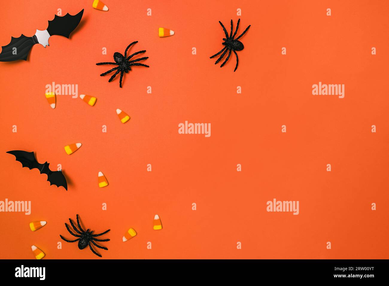 Halloween decor on the orange background, bats, spiders and candy cane ...