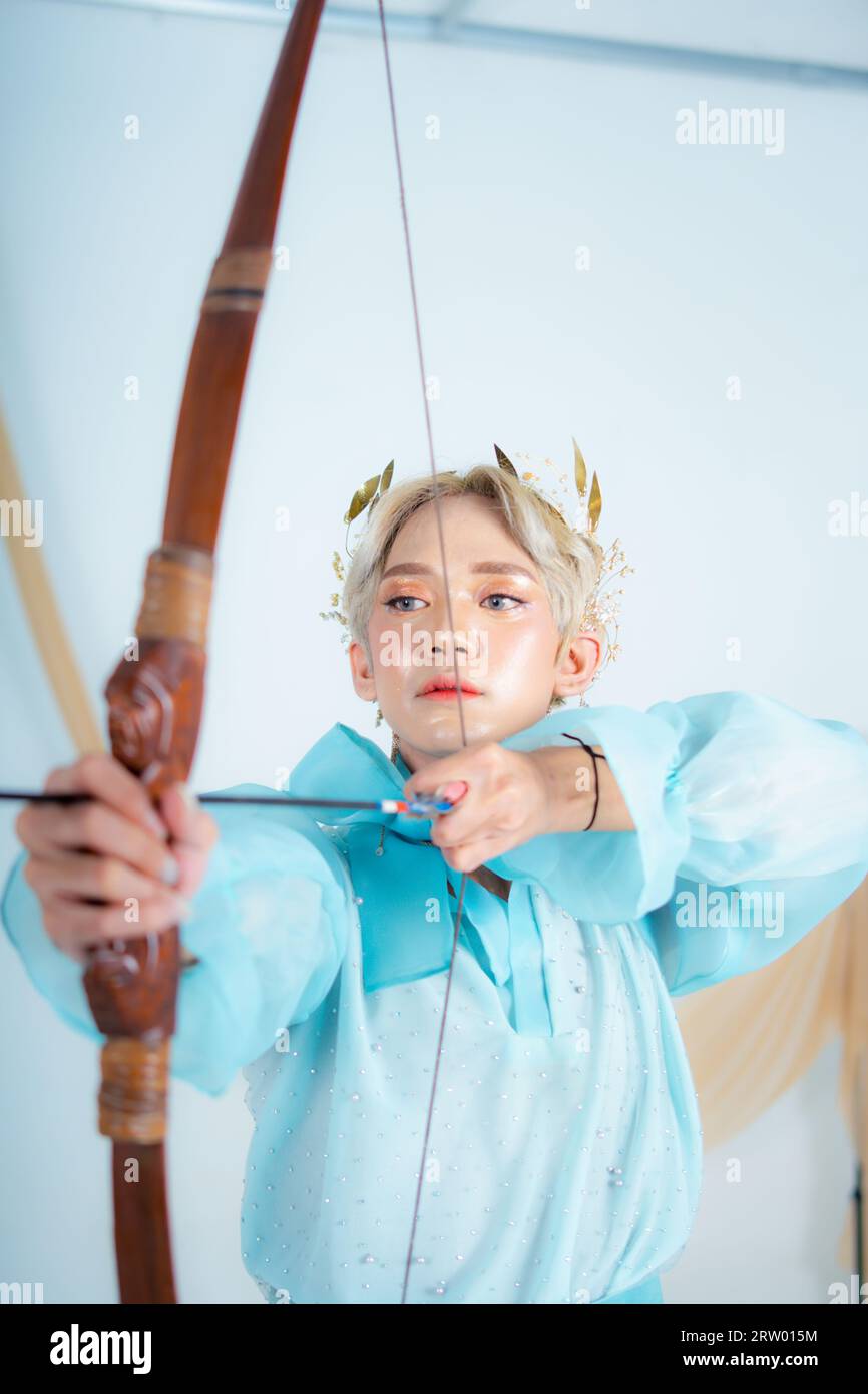 a princess in a blue dress pulling a bow with her hand in a white room ...