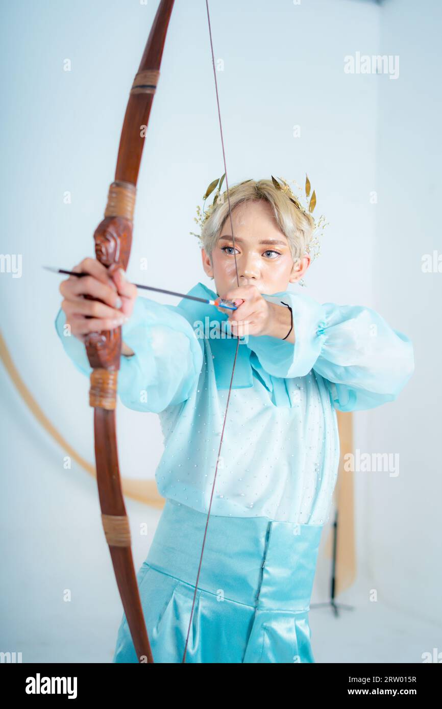 a princess in a blue dress pulling a bow with her hand in a white room ...