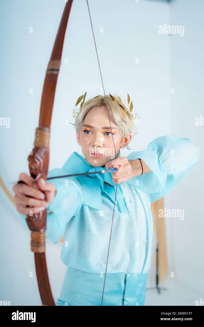 a princess in a blue dress pulling a bow with her hand in a white room ...