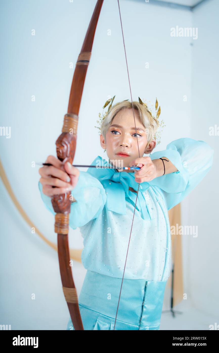 a princess in a blue dress pulling a bow with her hand in a white room ...