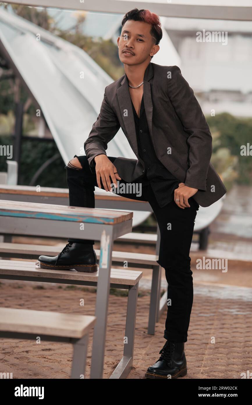 a grown man in a gray suit posing around a cafe table in a very manly ...