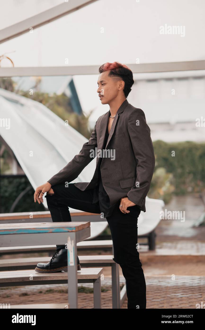 a grown man in a gray suit posing around a cafe table in a very manly ...