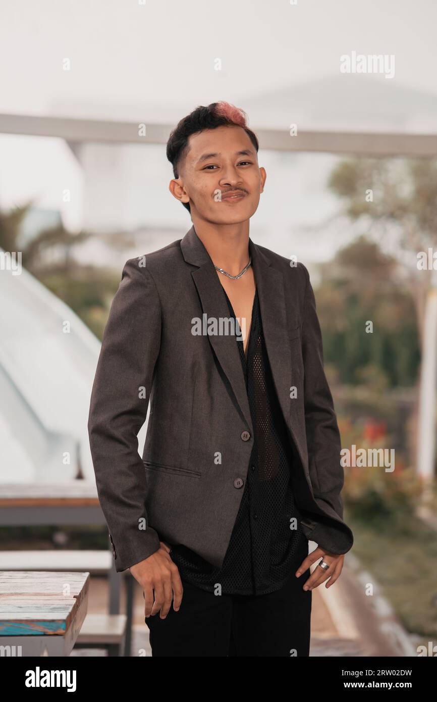 a grown man in a gray suit posing around a cafe table in a very manly ...