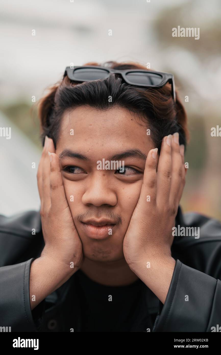 the face of a very silly Asian man with sunglasses on his head while ...