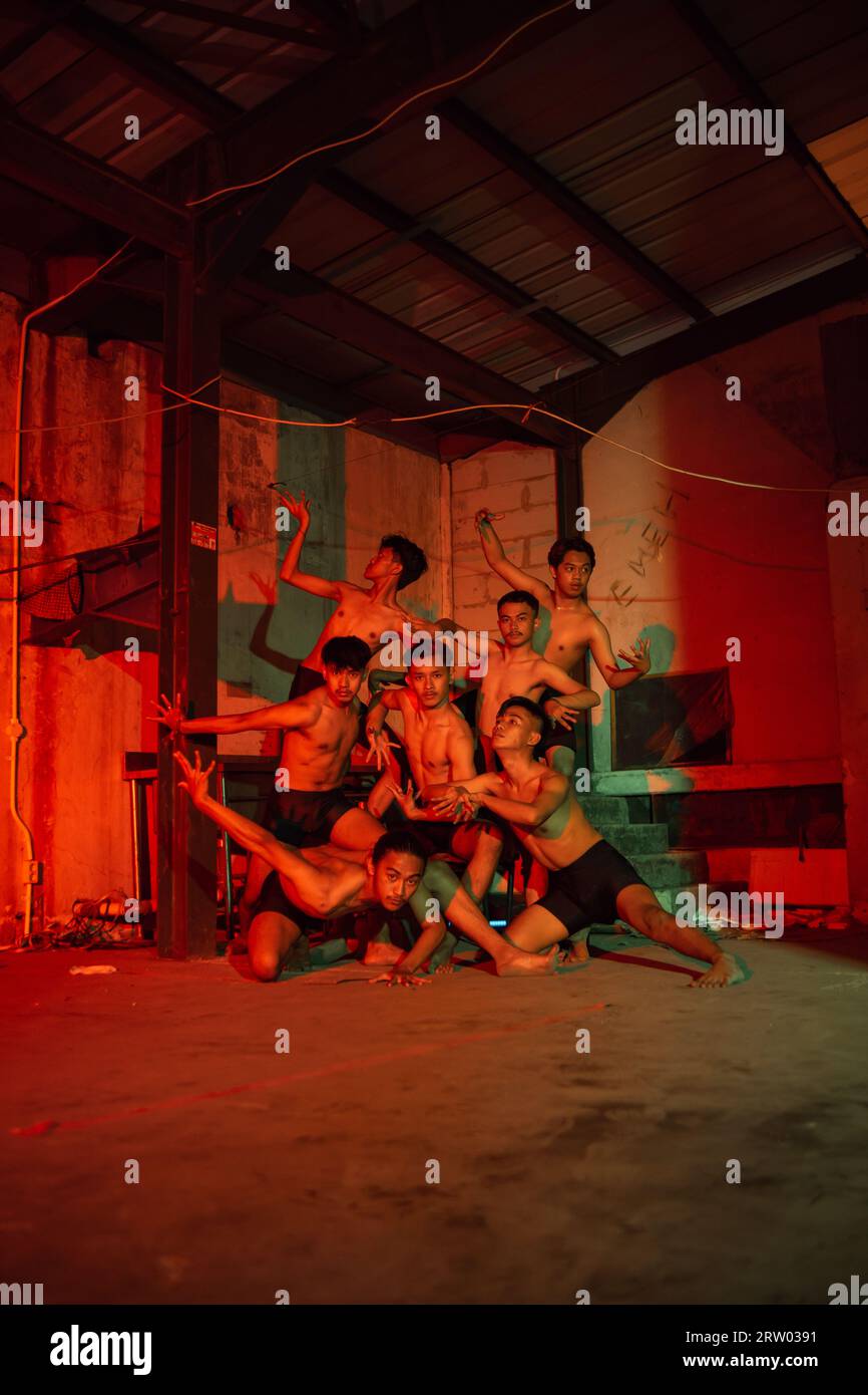 a group of men without clothes dancing poses in an old building with a ...