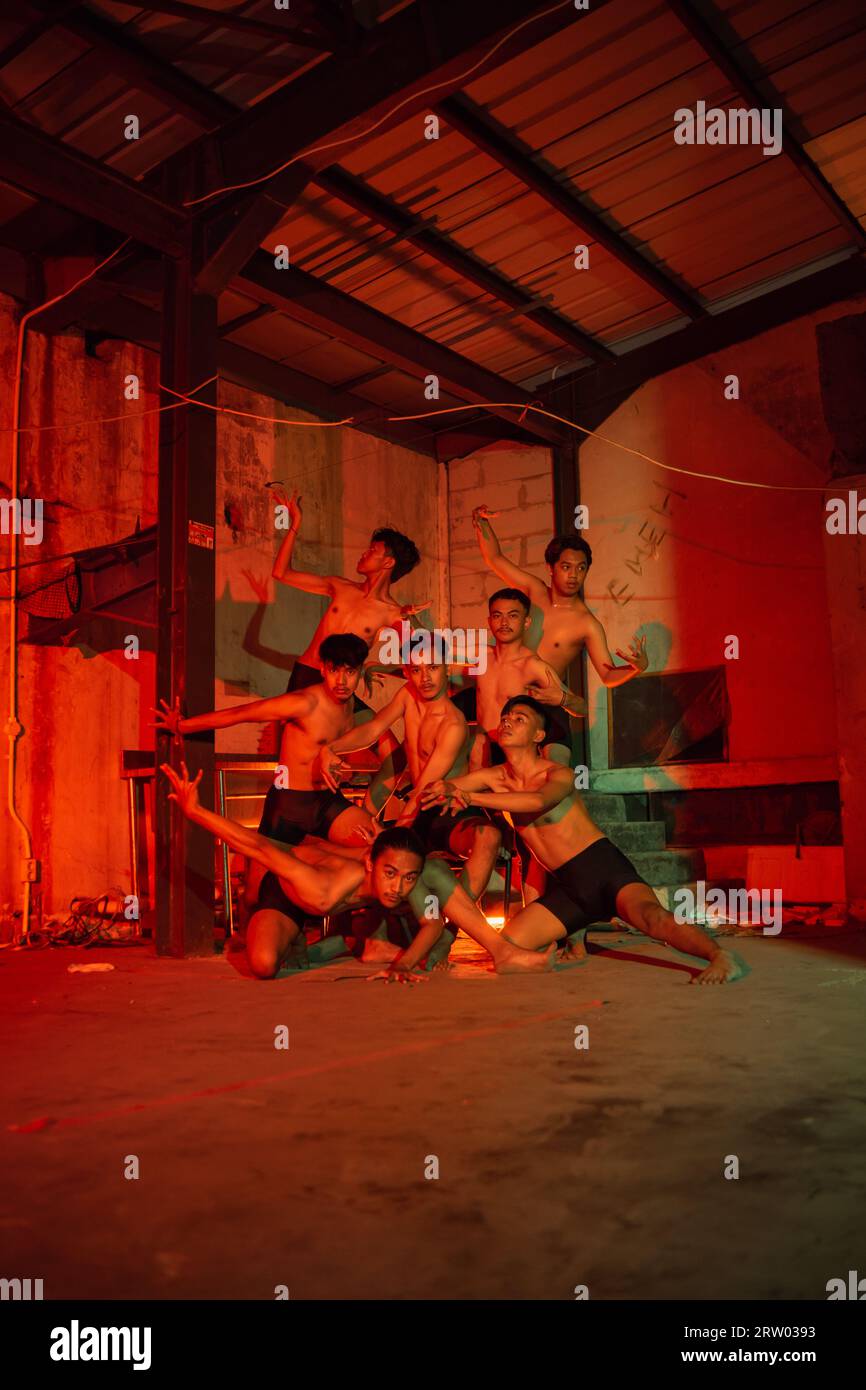 a group of men without clothes dancing poses in an old building with a ...