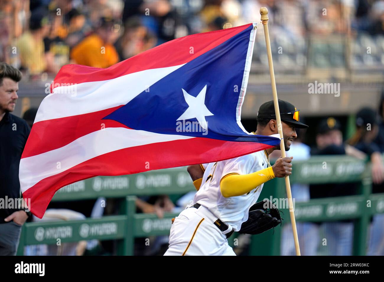 Pittsburgh Pirates right fielder Joshua Palacios carries the flag of ...