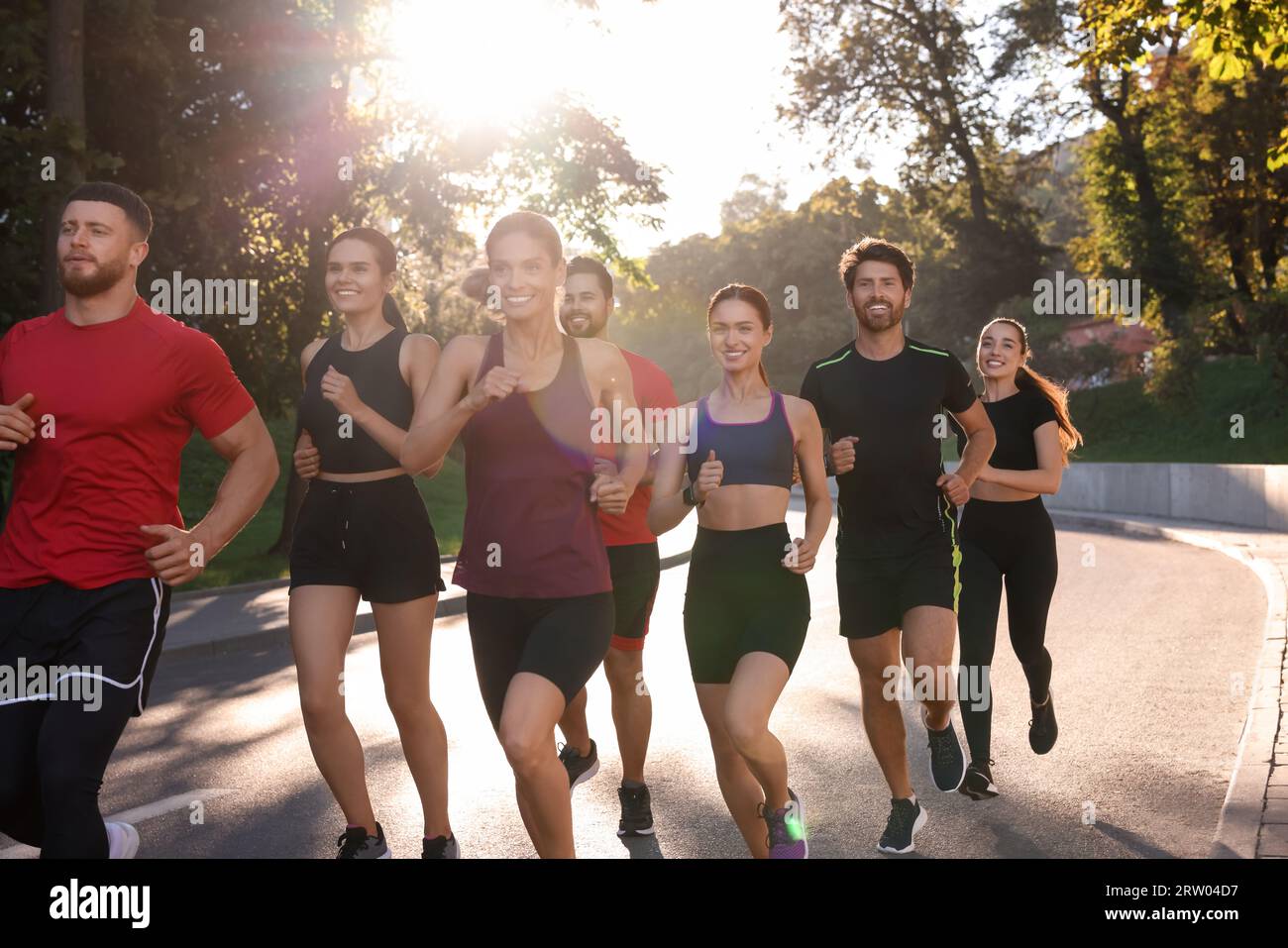 Group of people running outdoors on sunny day Stock Photo - Alamy