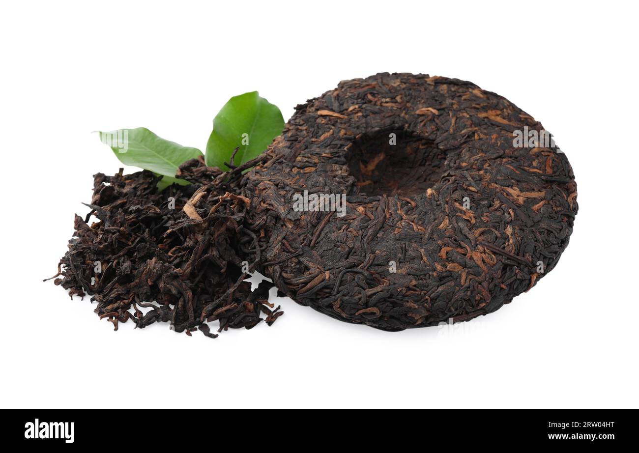 Broken disc shaped traditional Chinese pu-erh tea and fresh leaves ...
