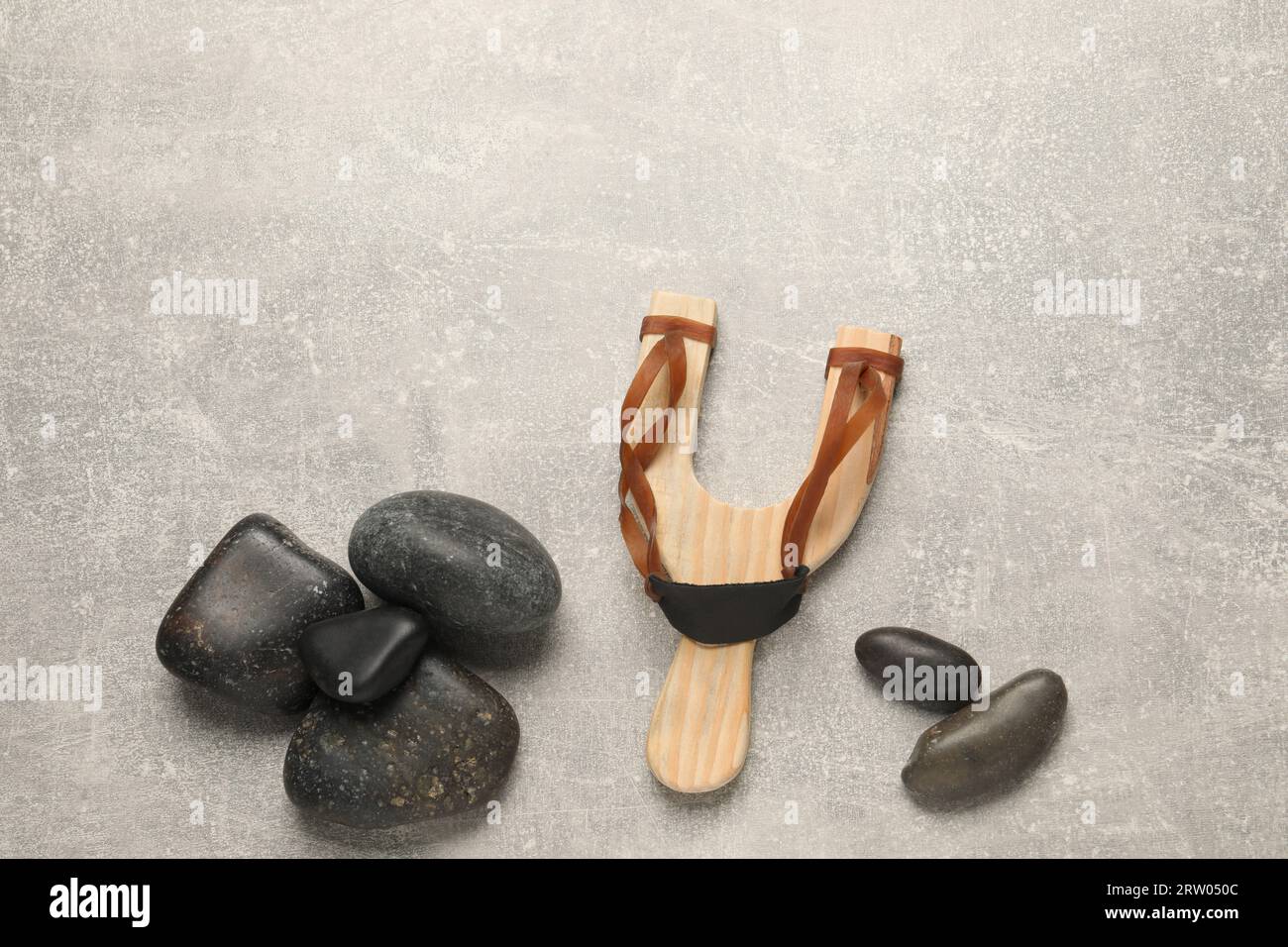 Slingshot with stones on light grey background, flat lay Stock Photo ...