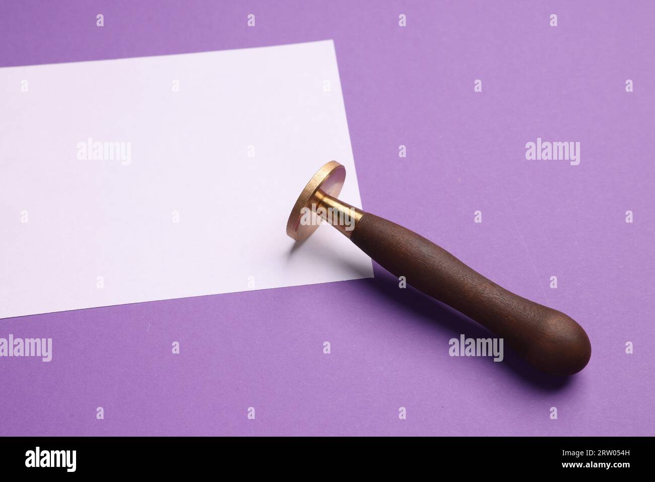 One stamp tool and sheet of paper on purple background Stock Photo - Alamy