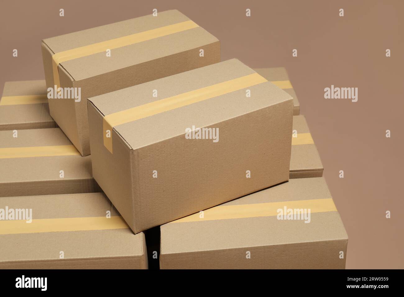 Many cardboard boxes on light brown background Stock Photo - Alamy