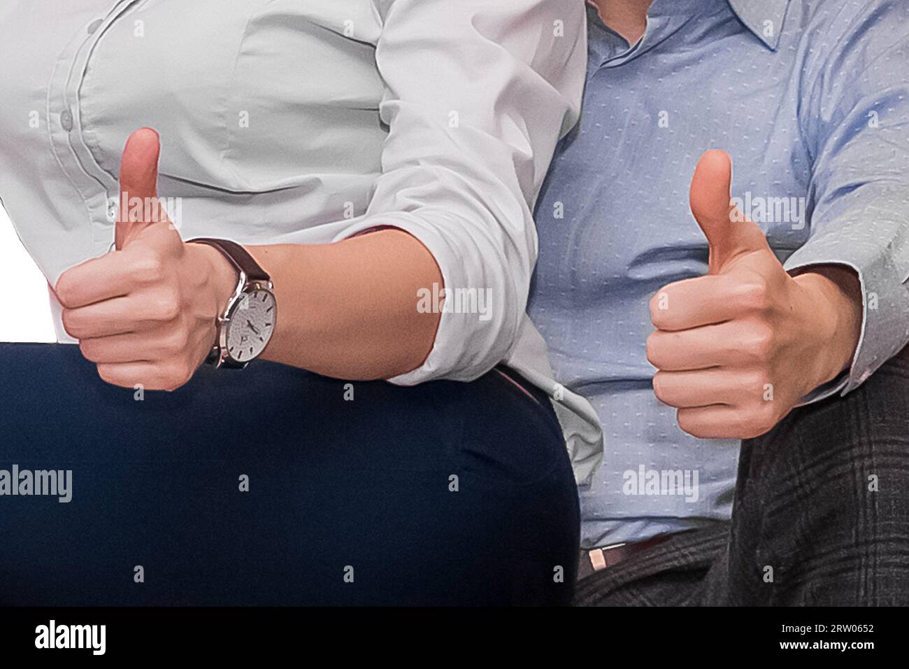 The hand of a girl and man shows the class with a cool thumbs up close ...