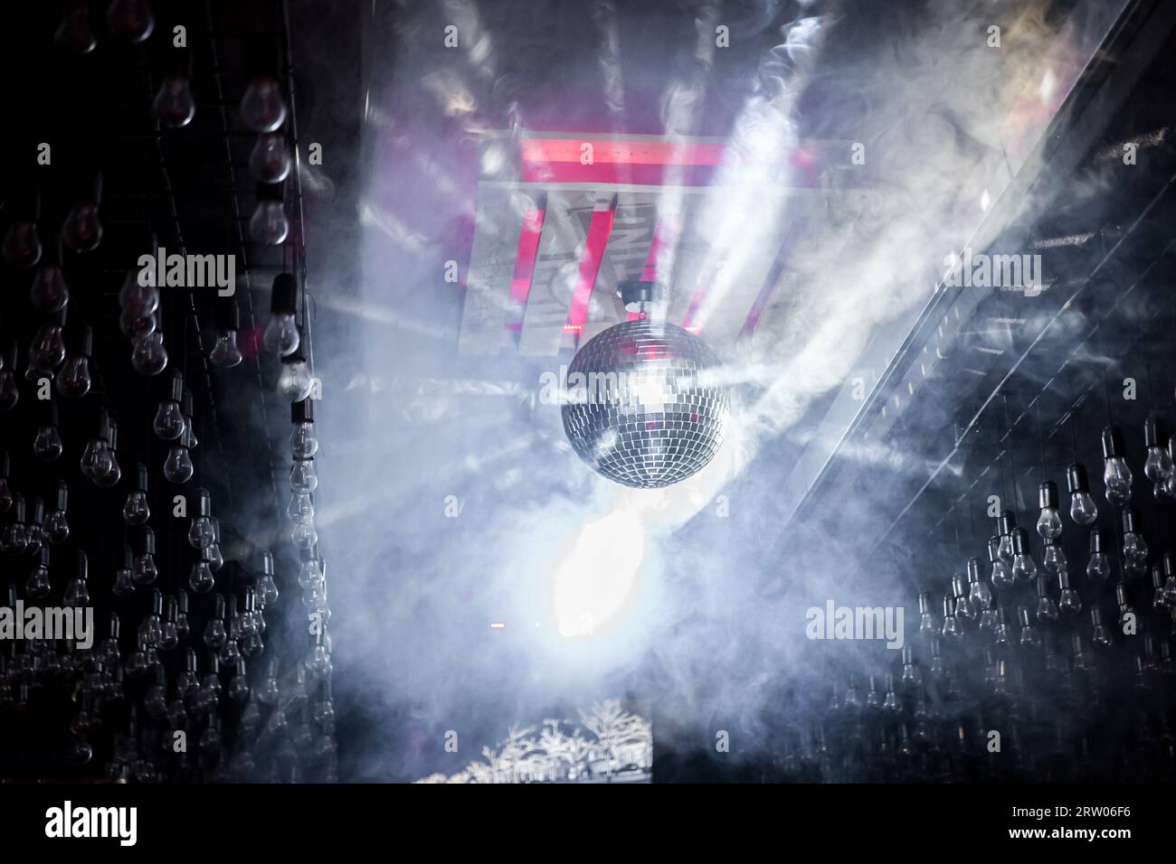 Disco bright shiny ball on the ceiling in smoke in the interior of a ...