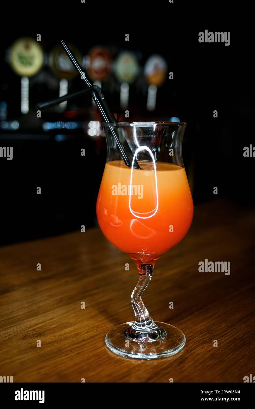 Red-orange bright alcoholic summer cocktail in a glass glass with a ...