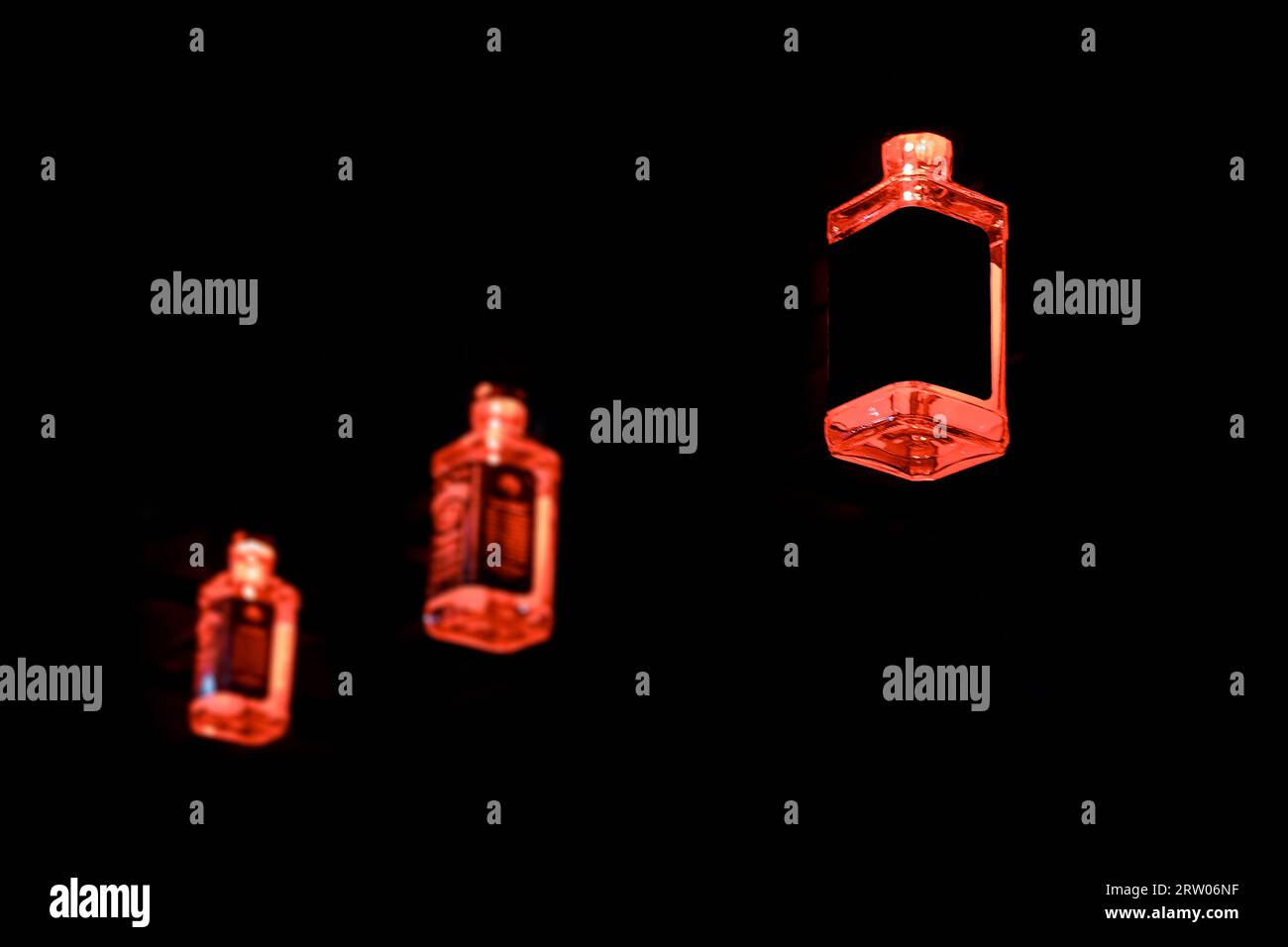 3 red bottles in neon light decoration of the modern interior of the ...